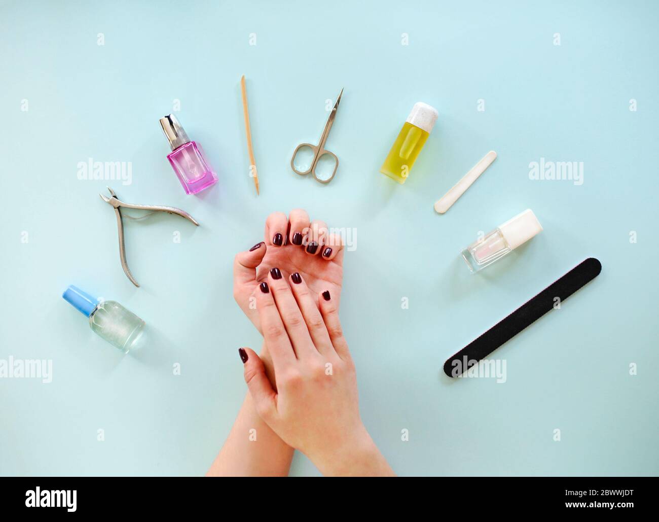 Top view of crop anonymous female with dark manicure sitting at table ...