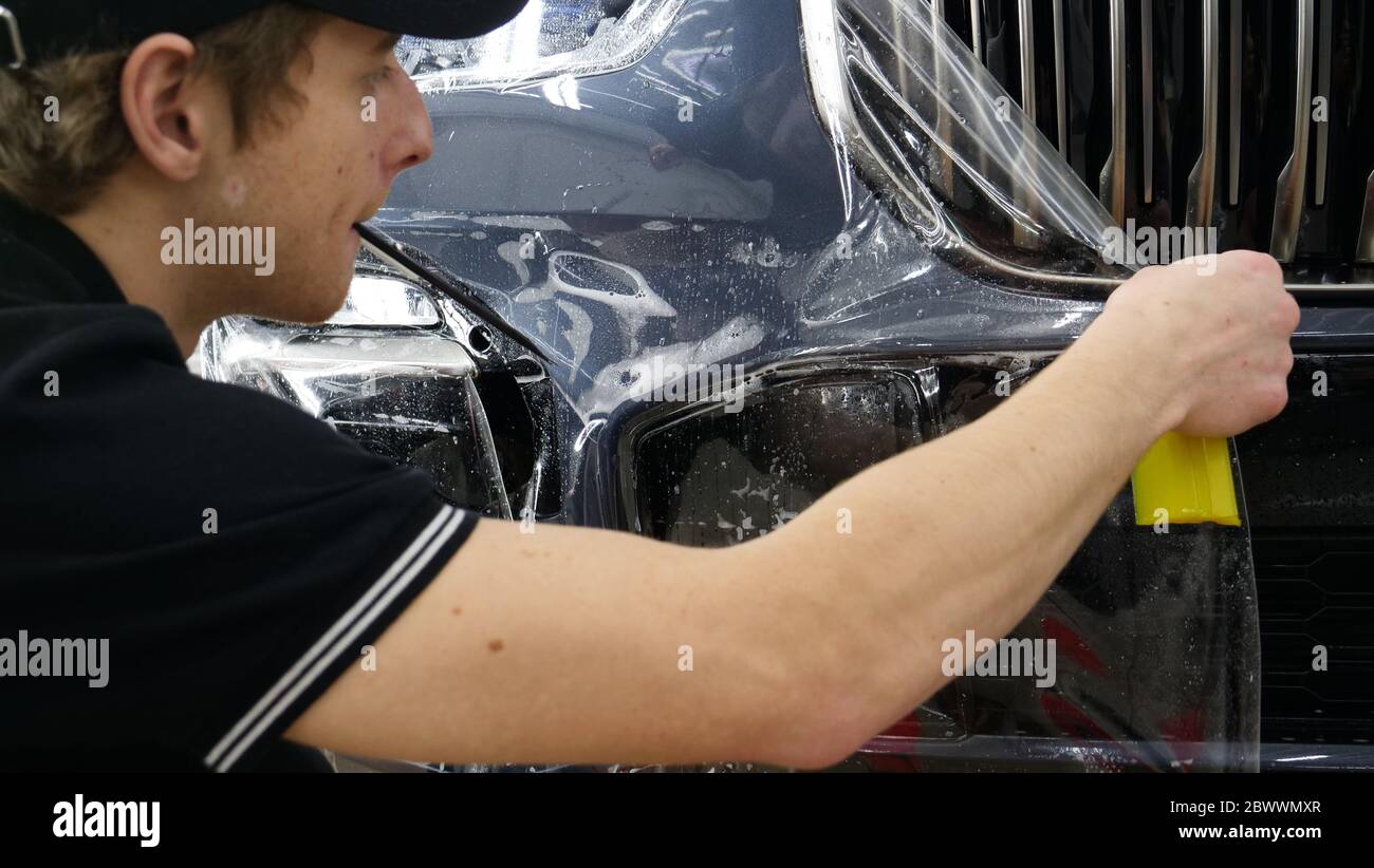 Paint protection film installation on side panel surface of luxury ...