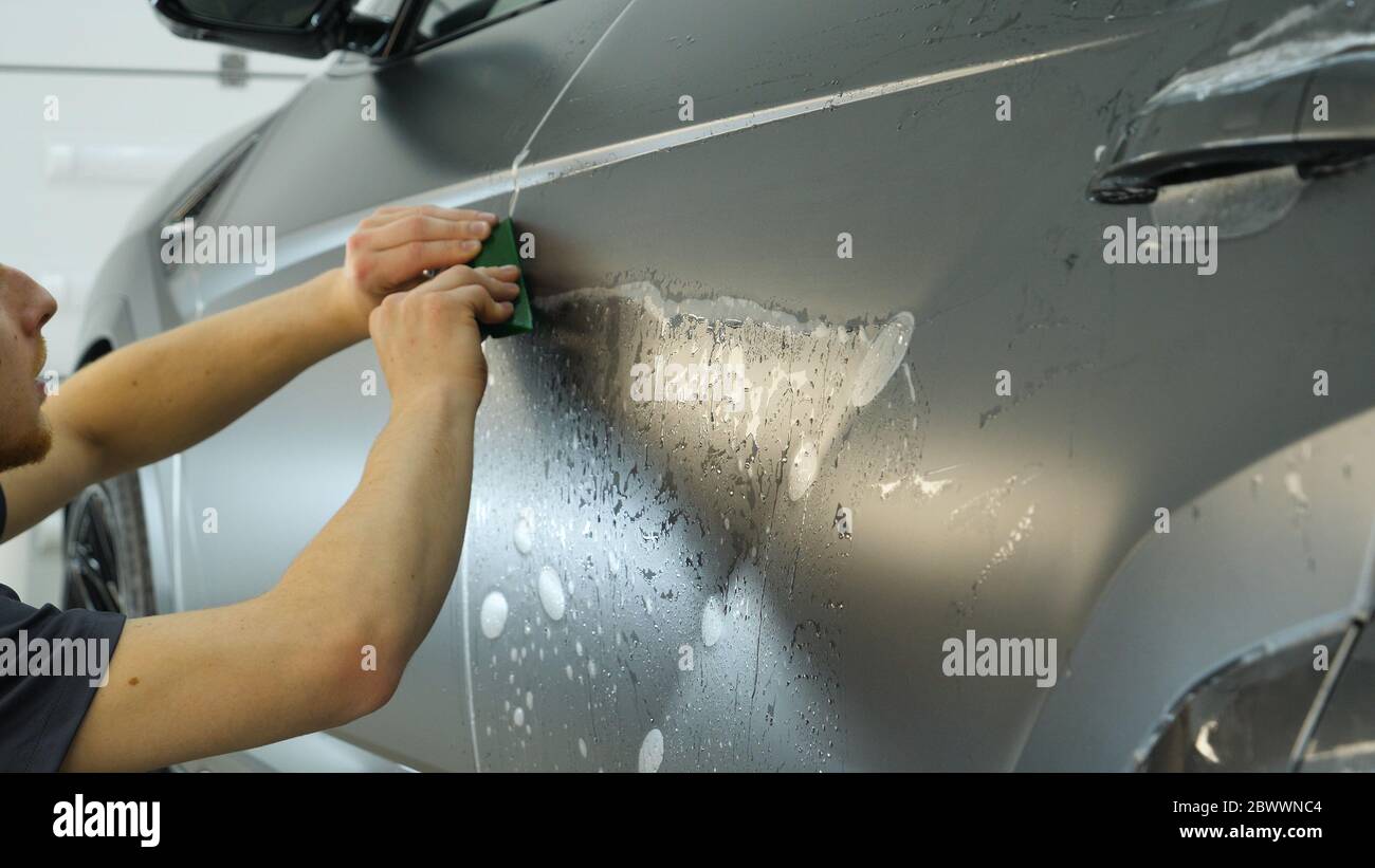 Paint protection film installation on side panel surface of luxury ...