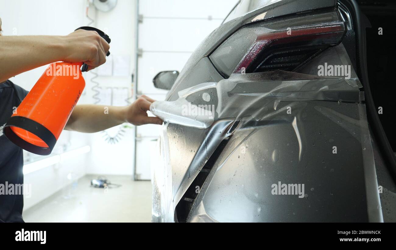 Paint protection film installation on side panel surface of luxury ...