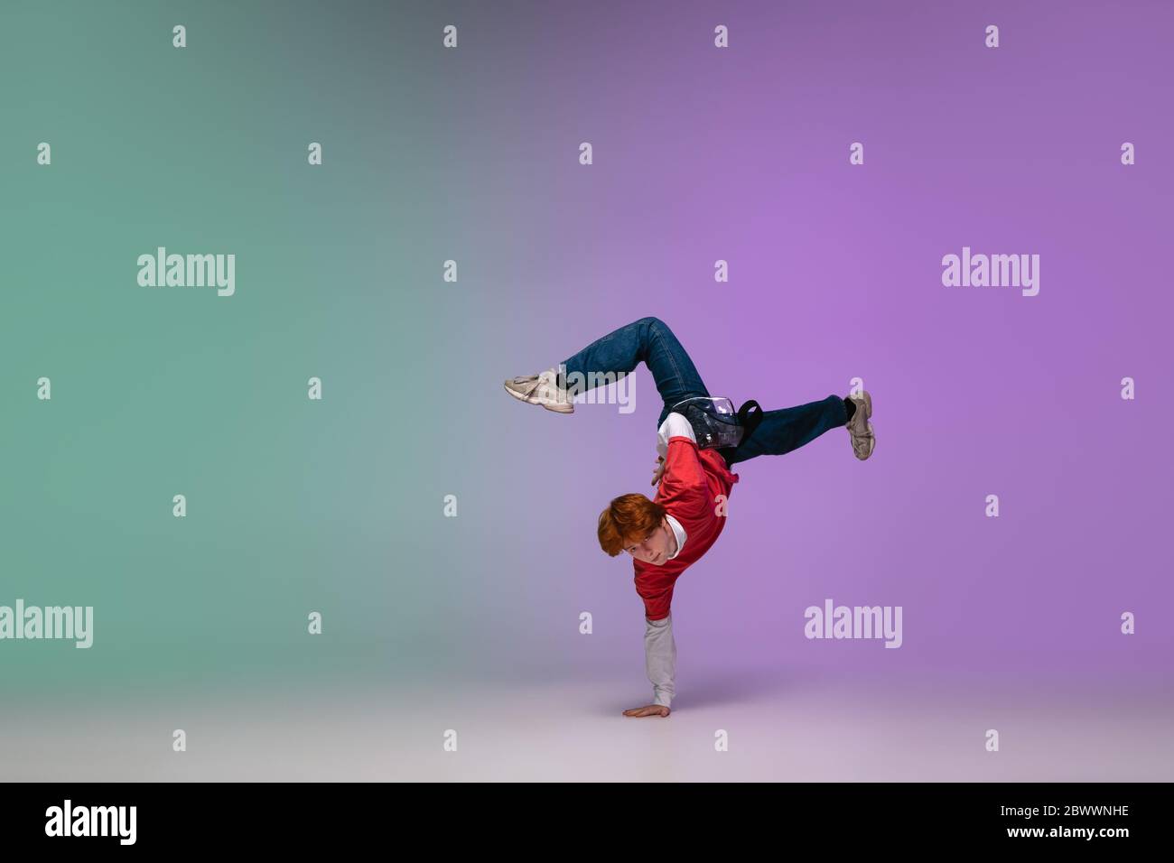 Beautiful sportive boy dancing hip-hop in stylish clothes on colorful ...