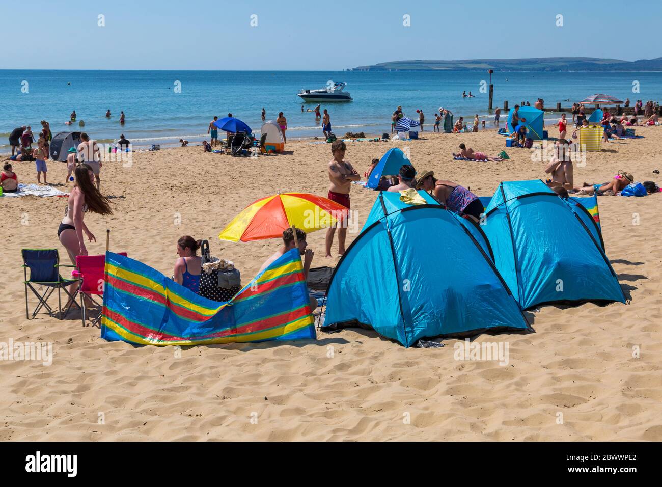 Beachgoers enjoy the sunshine on scorching hot sunny day at Bournemouth ...