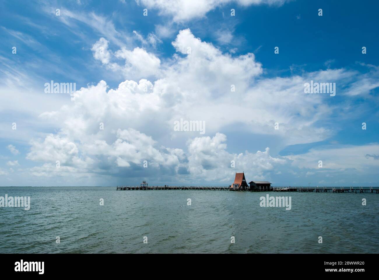 The view of a long wooden pier in Belize City under the picturesque ...