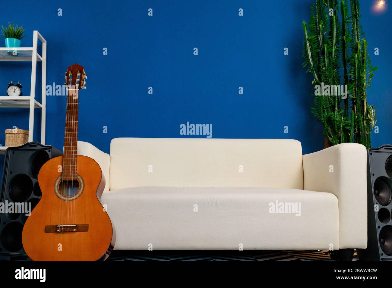 Wooden acoustic guitar near white sofa in modern living room Stock ...