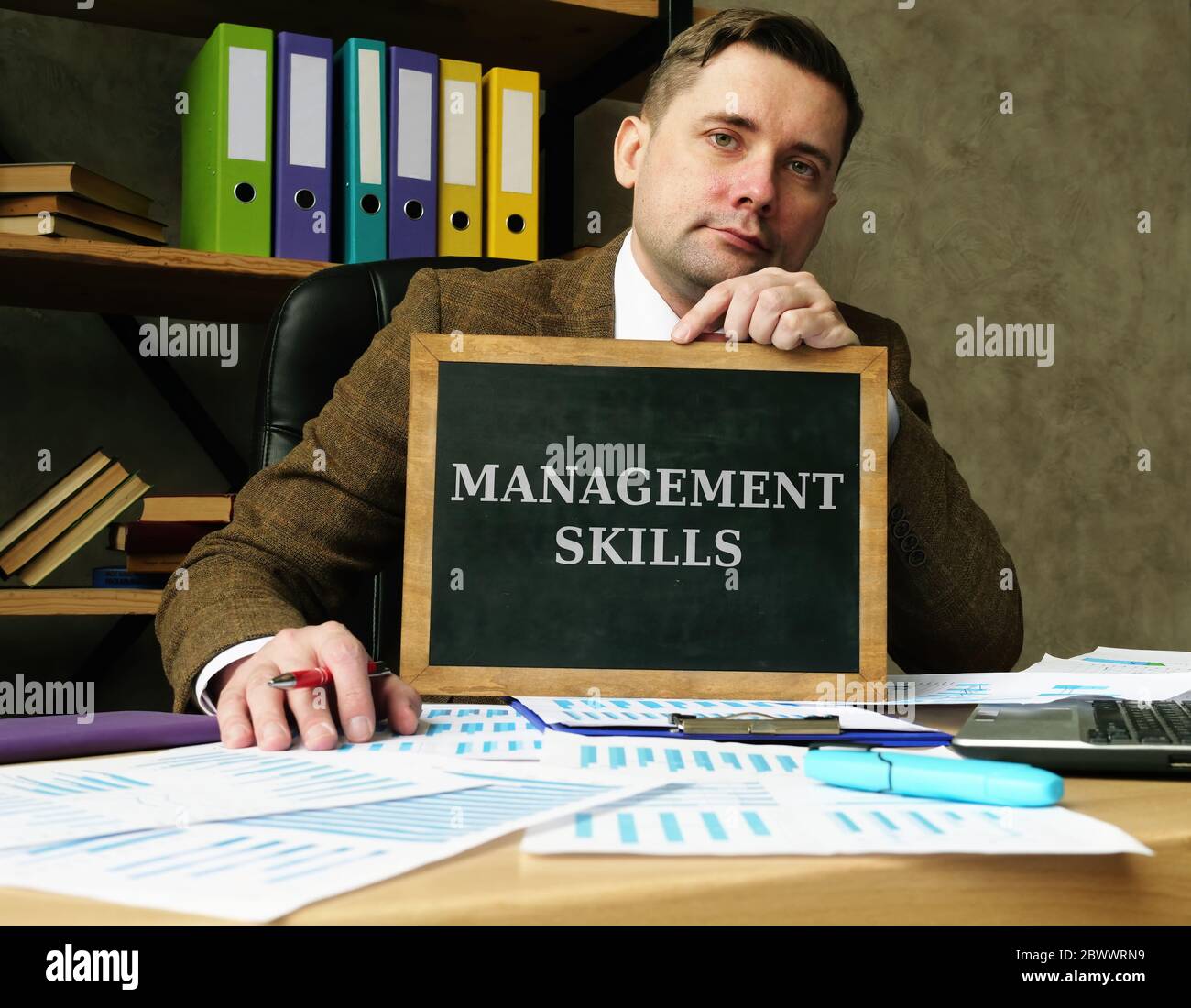 Manager holds board with words Management Skills Stock Photo - Alamy