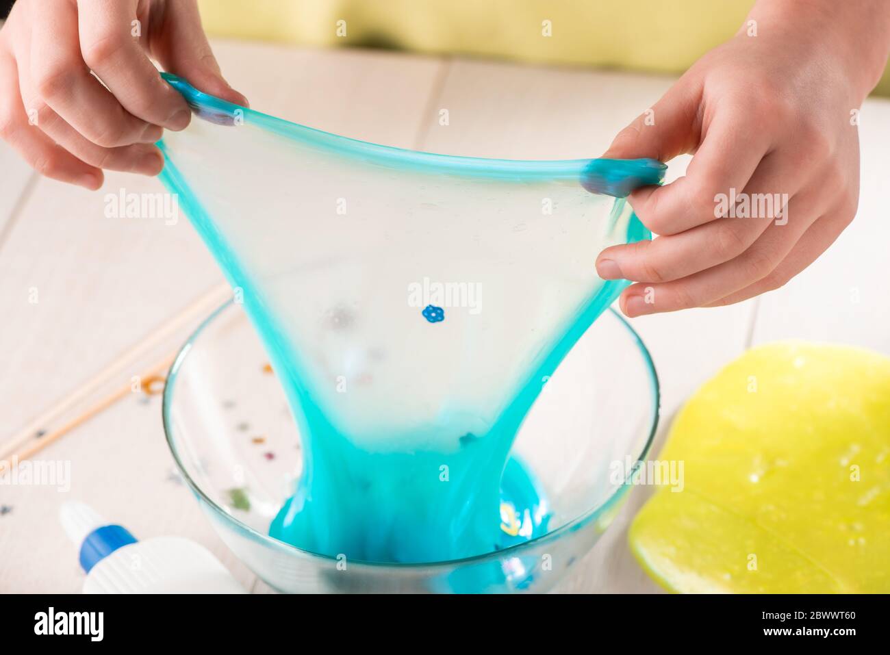 Child playing with blue slime and stretching it Stock Photo - Alamy
