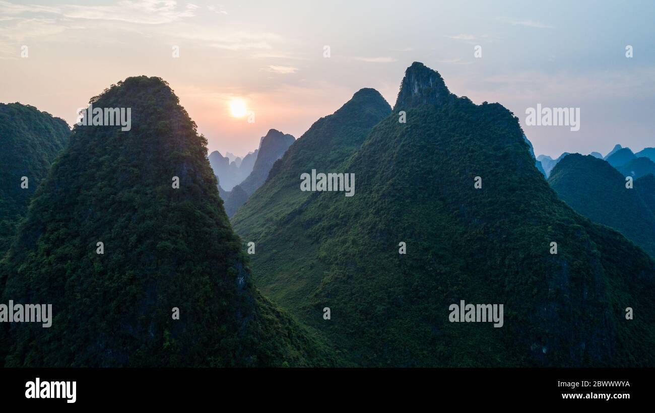 sunset on a river with karst mountains Stock Photo - Alamy