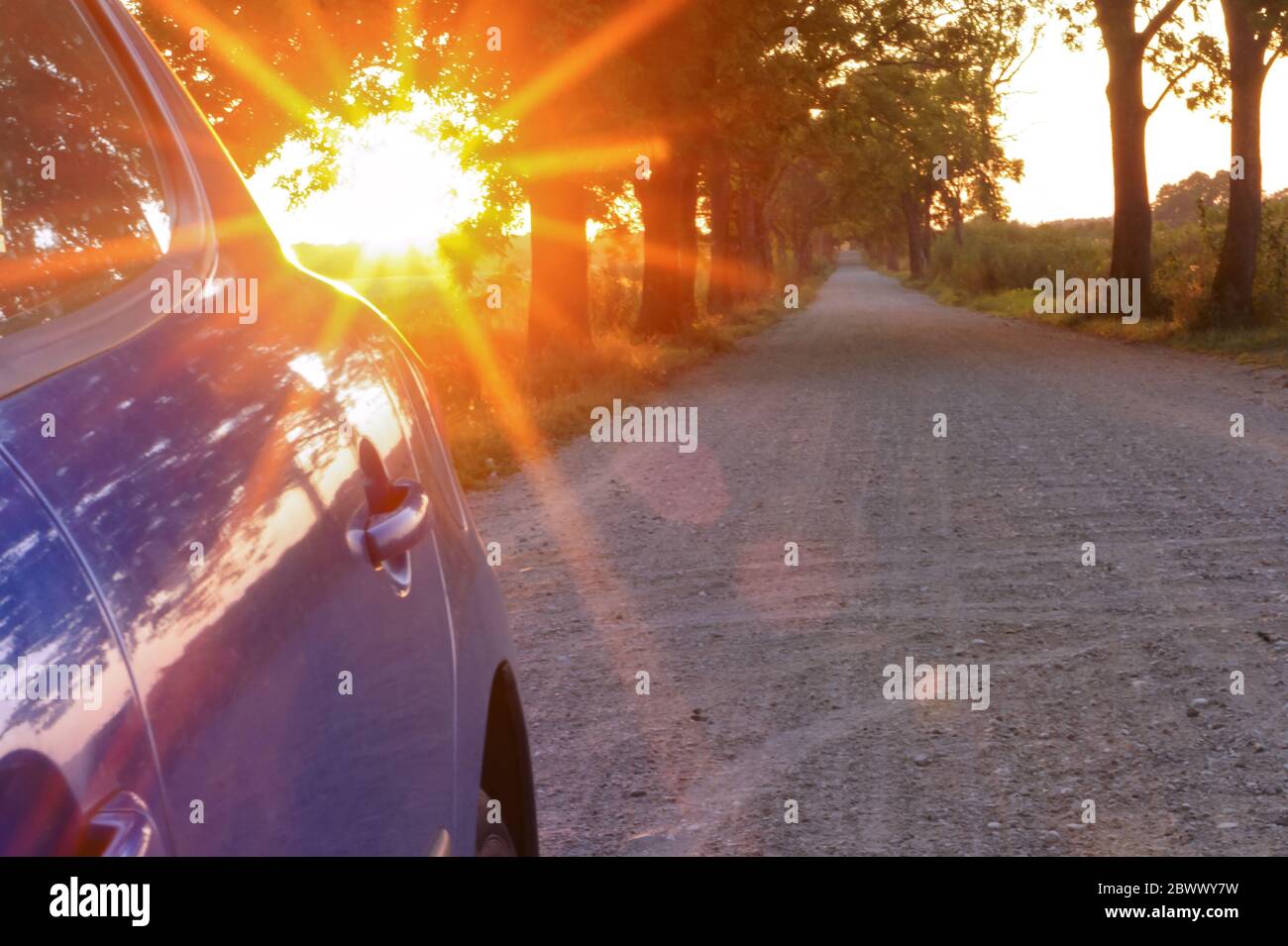 the sunset and the car, the sun's rays blue cars on the road Stock ...