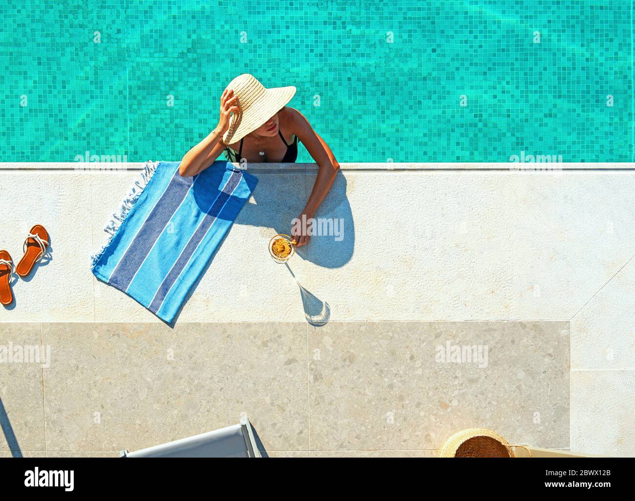 Top view from above of turqiuose swimming pool with young woman, bikini ...