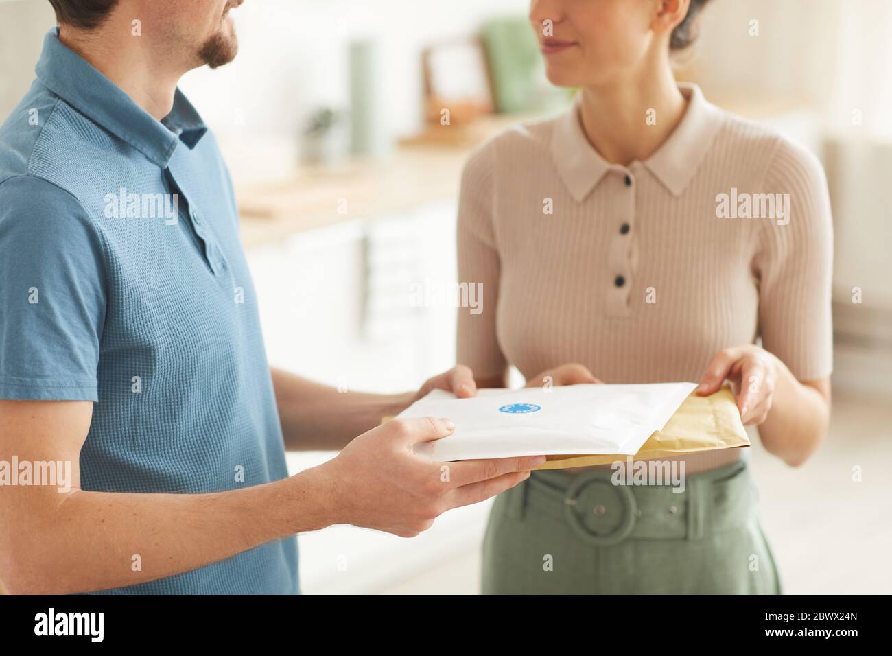 Close-up of young woman getting the letters from delivery man in the ...