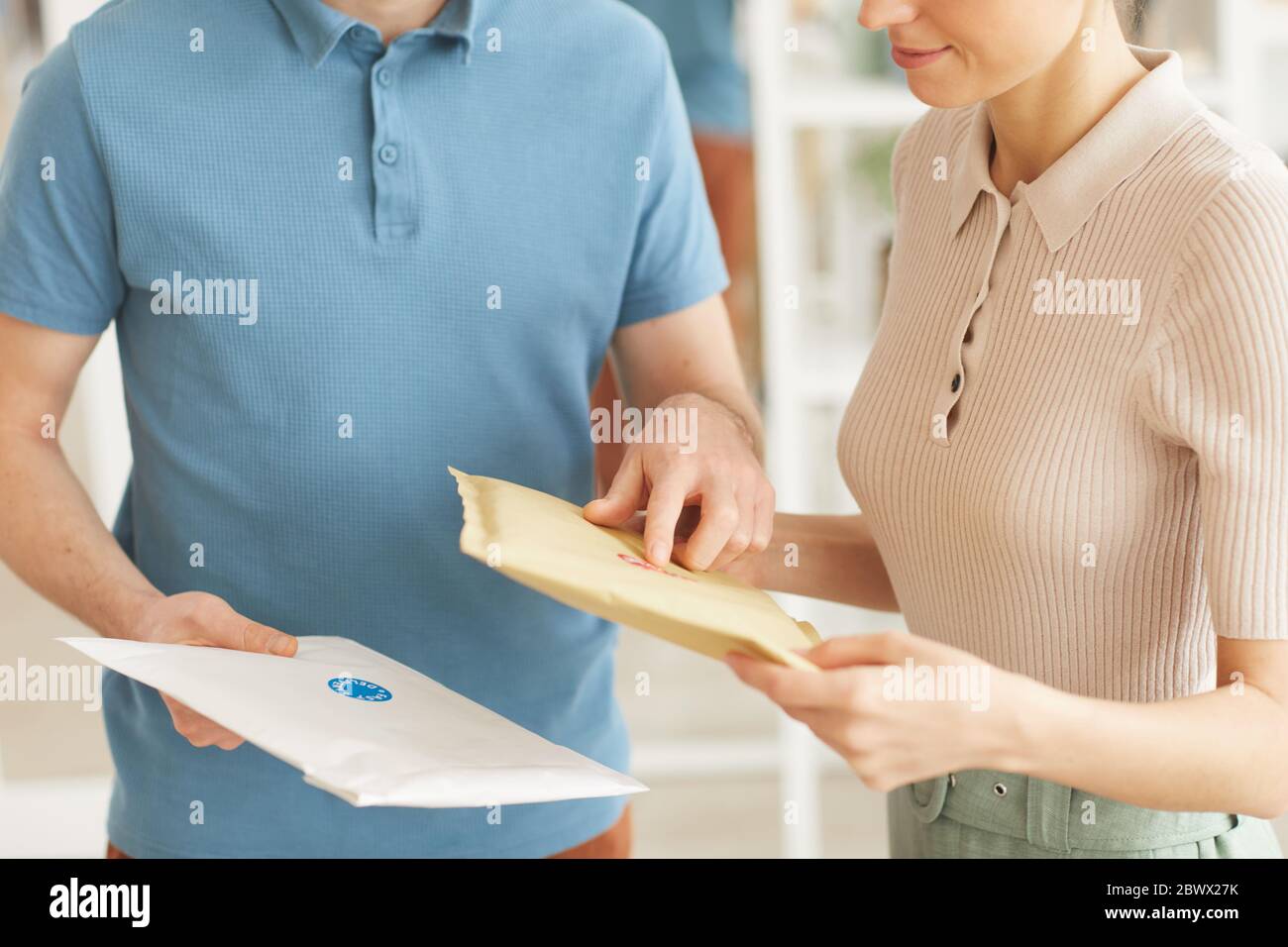 Close-up of man delivering letters to young woman at home Stock Photo ...
