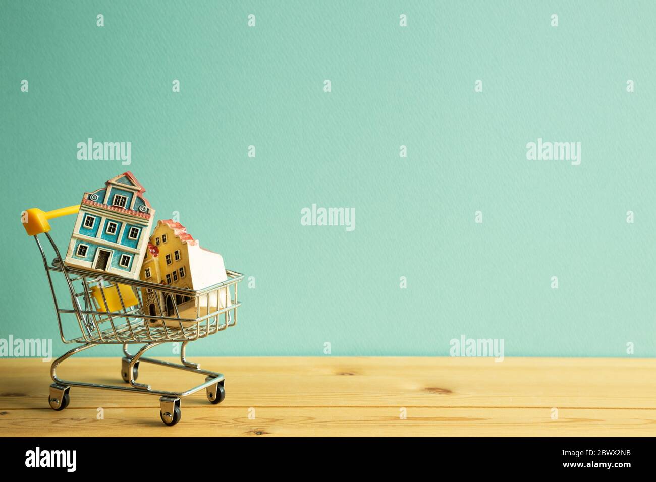 House model in shopping cart with copy space, Real estate buying a ...
