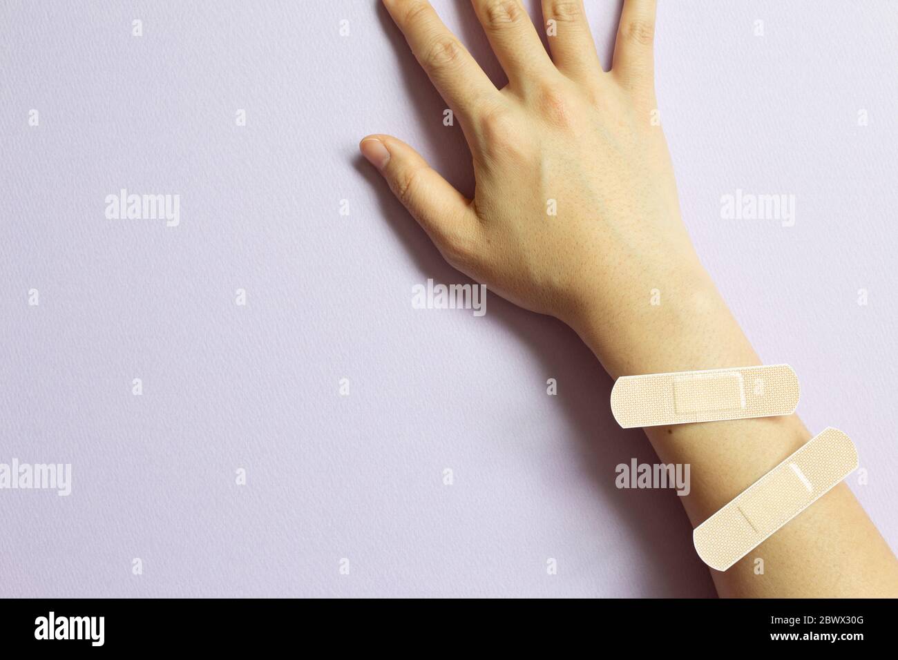 Band aid with human hand on purple background. medical concept. simple ...