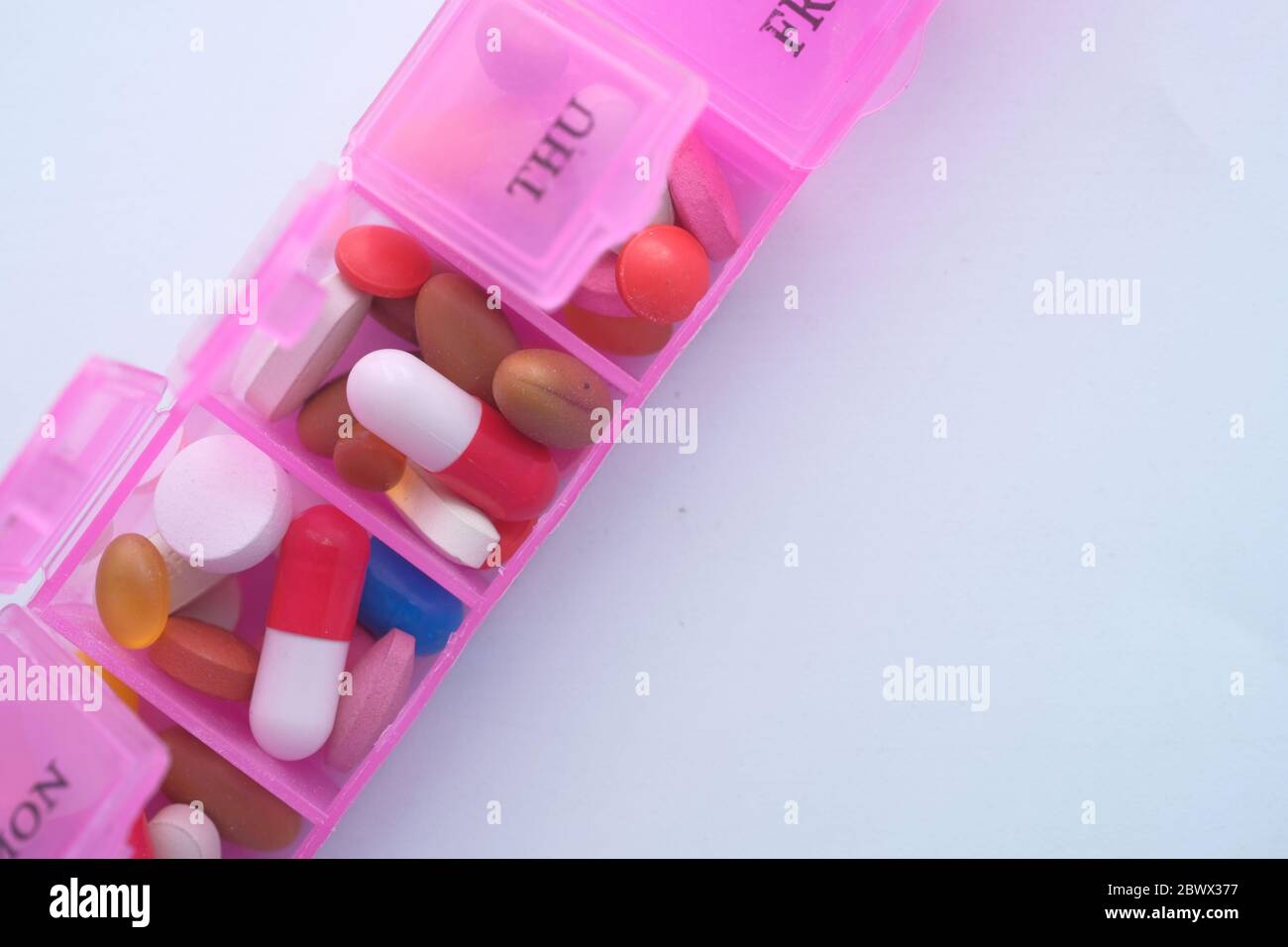 Top view of pink color pill box on white background Stock Photo - Alamy