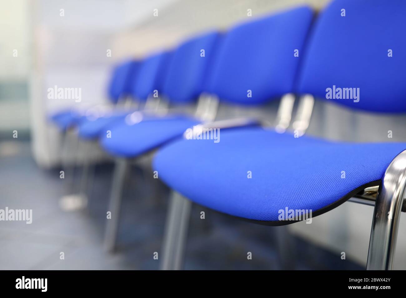 Line of empty blue visitor chairs at reception or in bank Stock Photo ...