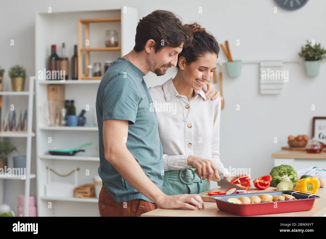 Young couple preparing food together in the kitchen they preparing dish ...