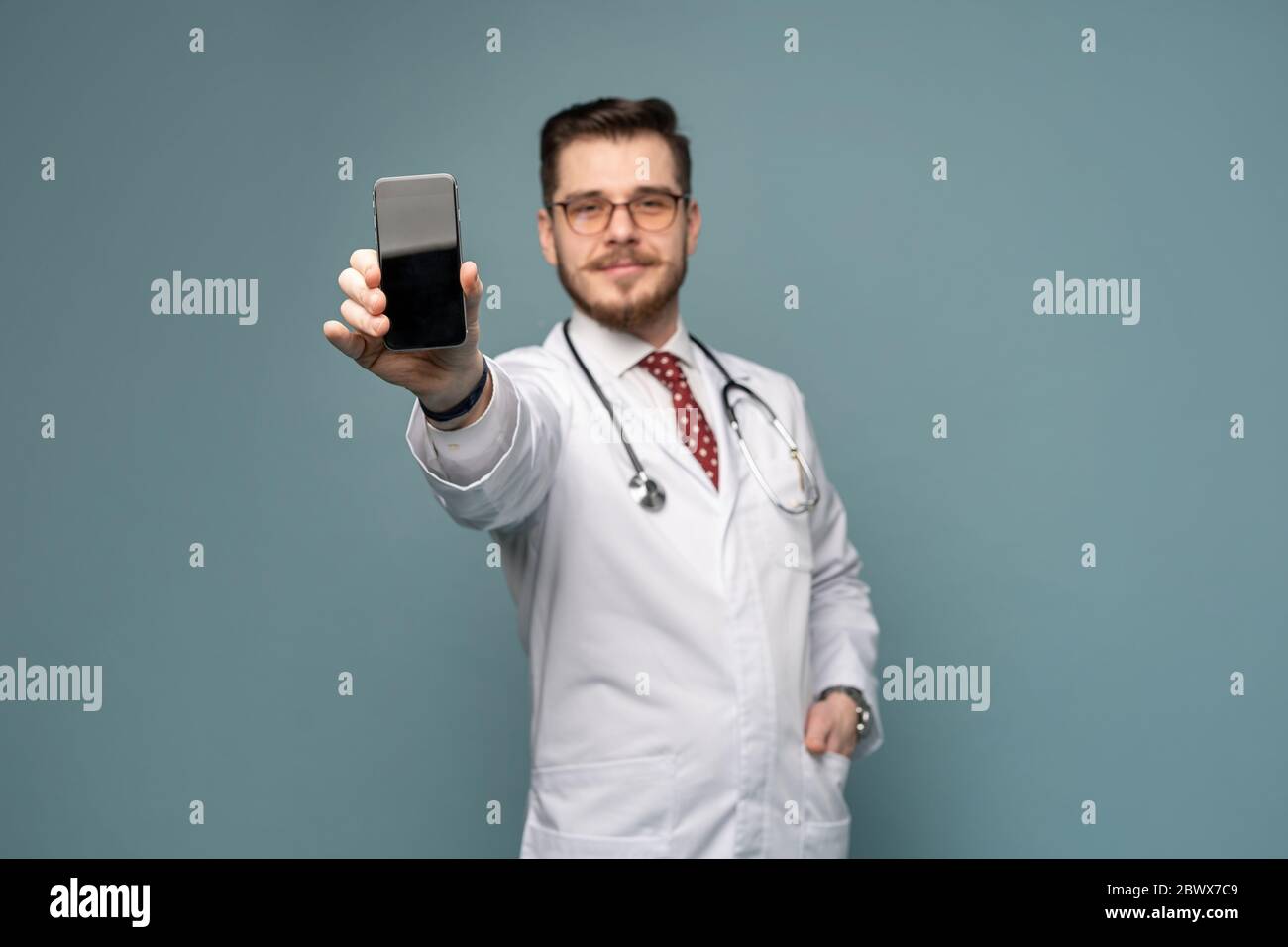 A portrait of a medical doctor posing against gray background Stock ...