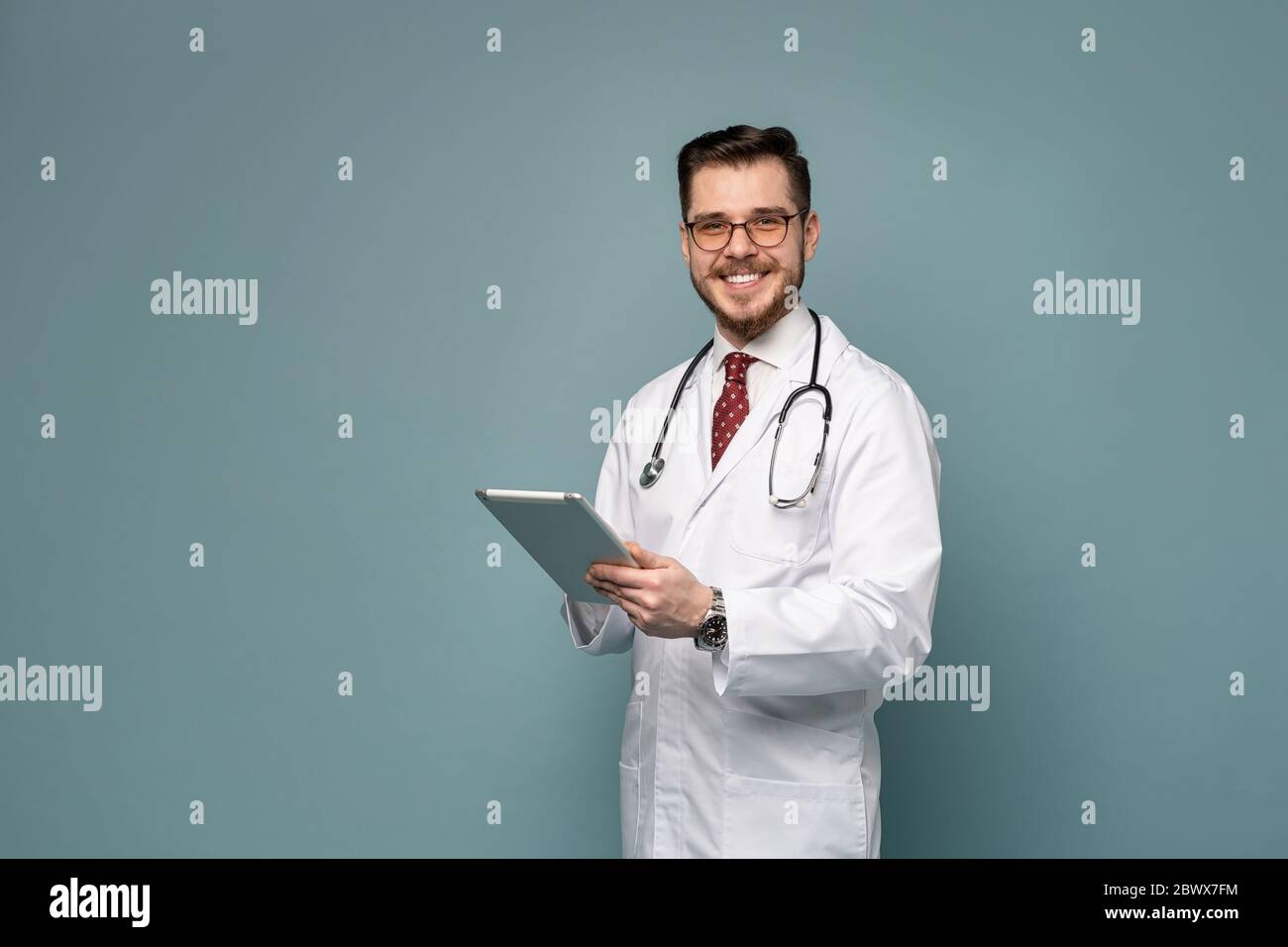 A portrait of a medical doctor posing against gray background Stock ...