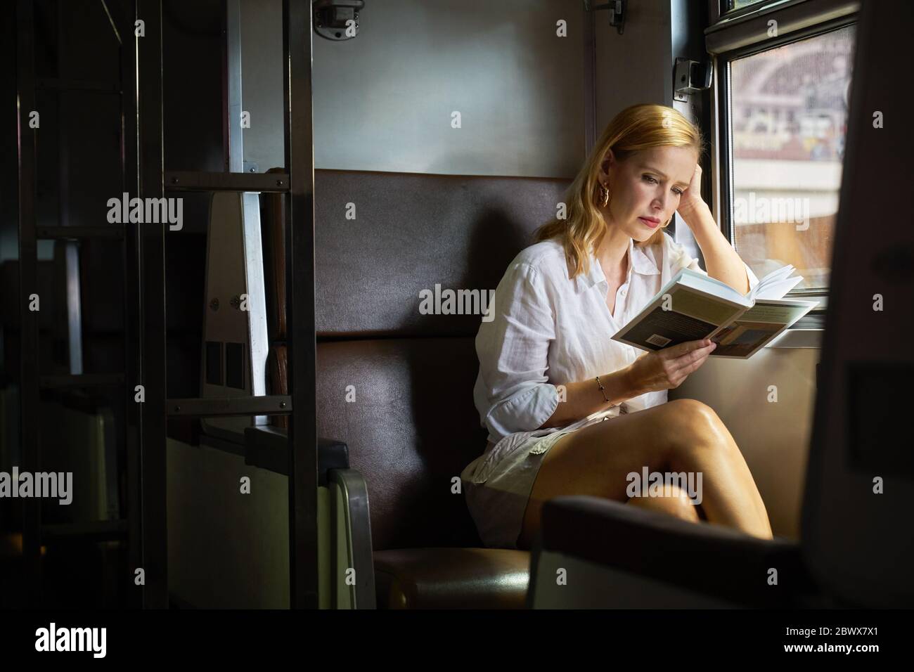 Woman reading book on a train hi-res stock photography and images - Alamy