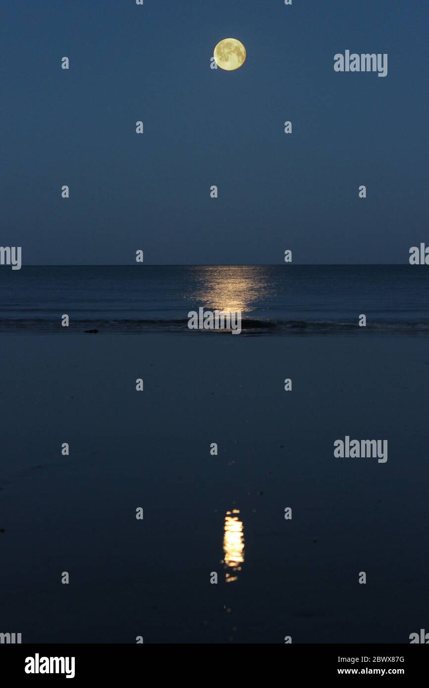 Full Moon setting over sea at Tywyn, Mid Wales Stock Photo - Alamy