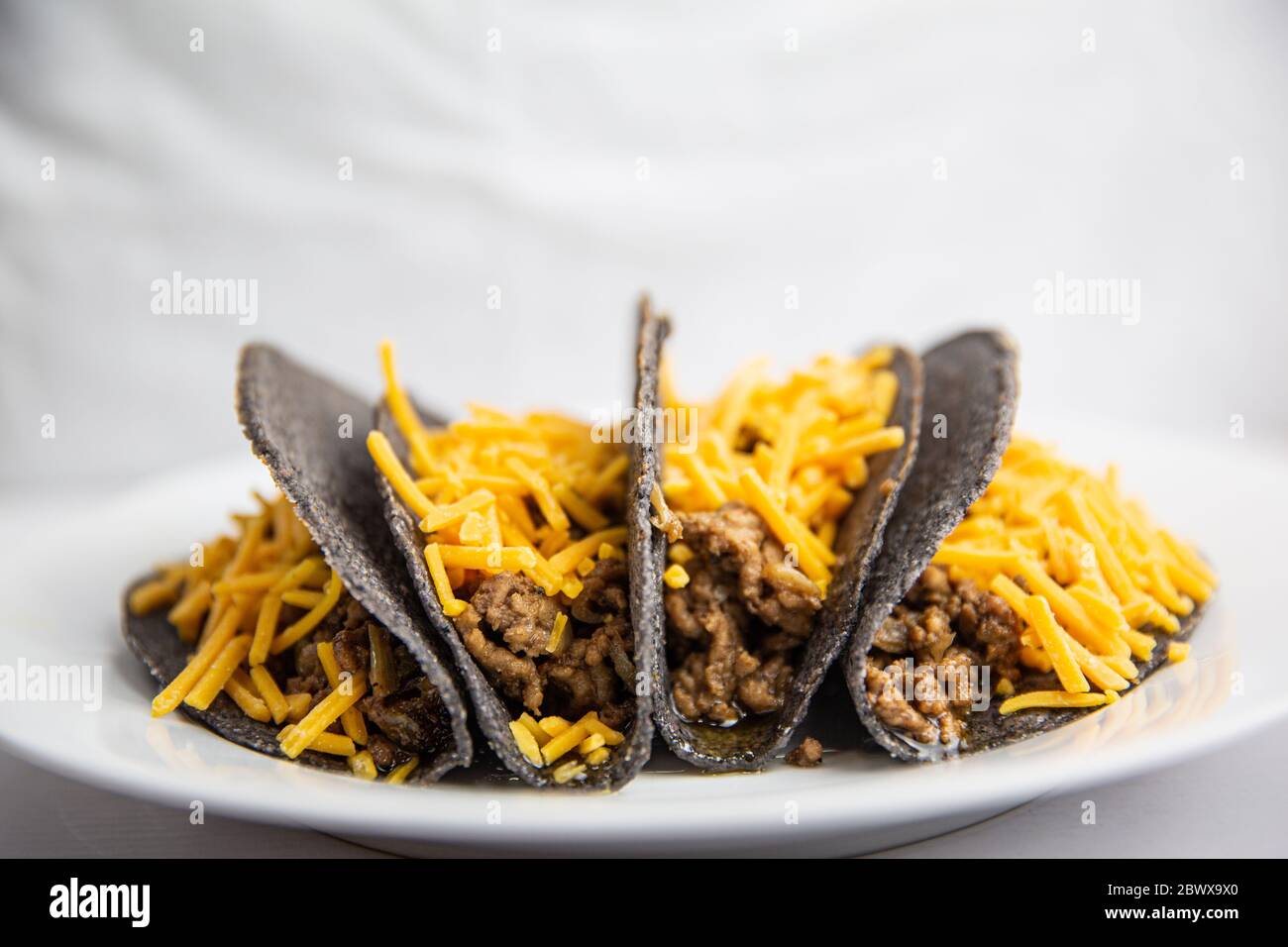 Classic hard shell blue corn tacos with ground beef and cheese on white ...