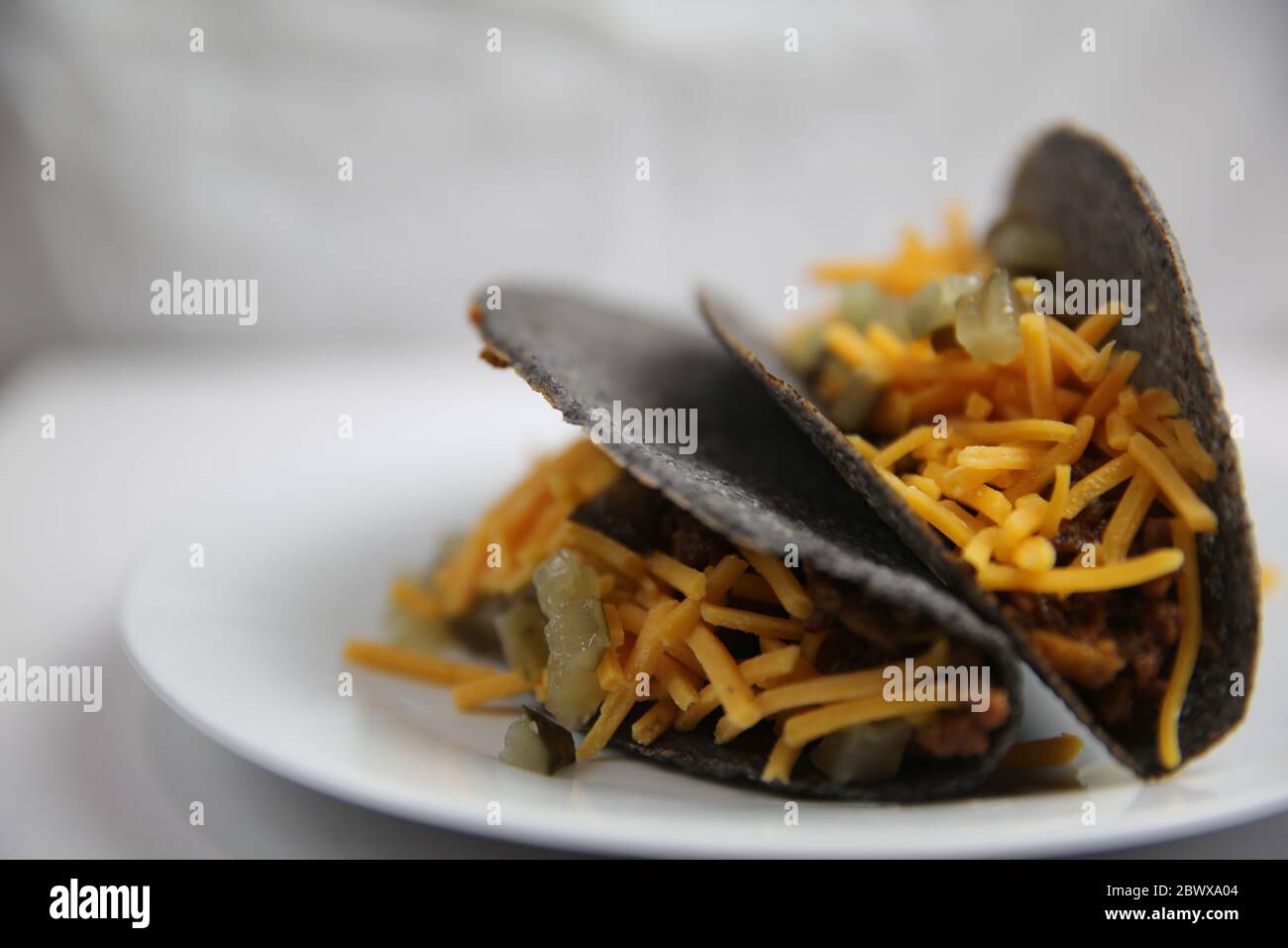 Classic hard shell blue corn tacos with ground beef and cheese on white ...