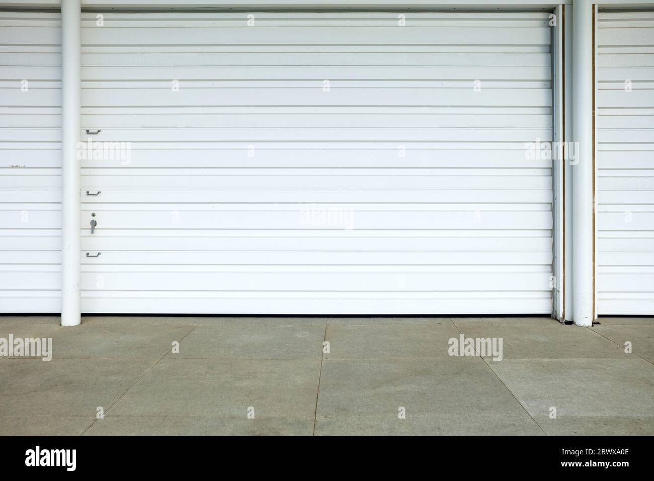 White Folding Metal Door with Concrete Pavement Stock Photo - Alamy