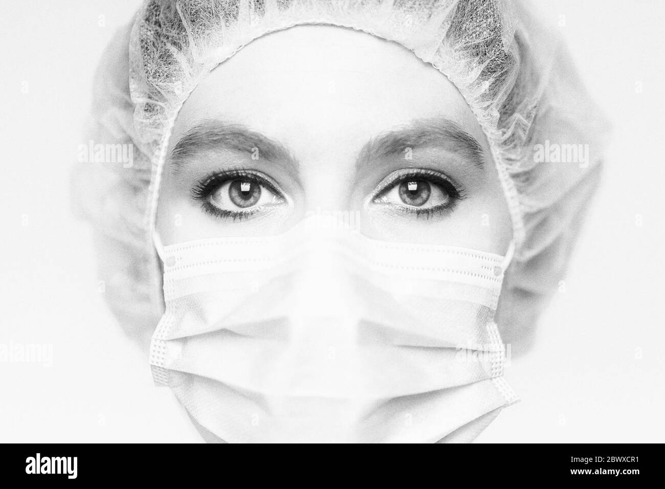 Close Up In Bandw Of A Female Nurse With A Penetrating Lookas Part Of A Medical Team Wearing