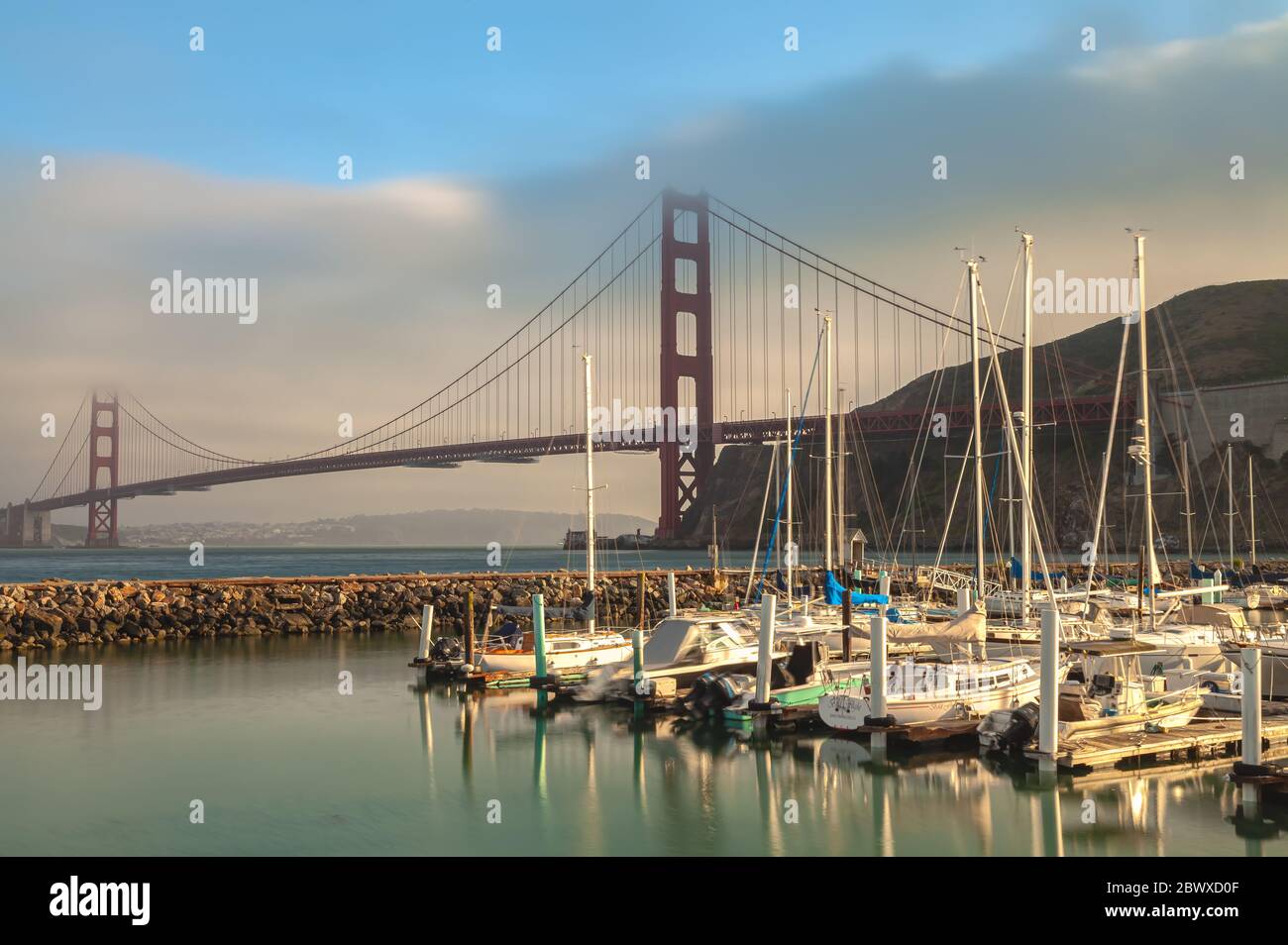 The Golden Gate Bridge at early evening as fog approaching the bay ...