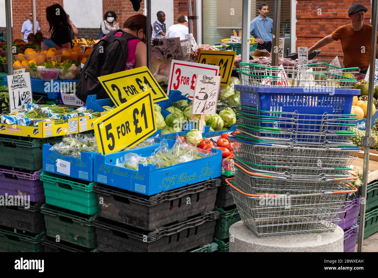 A outdoor fruit and vegetables market stall with signs advertising good ...