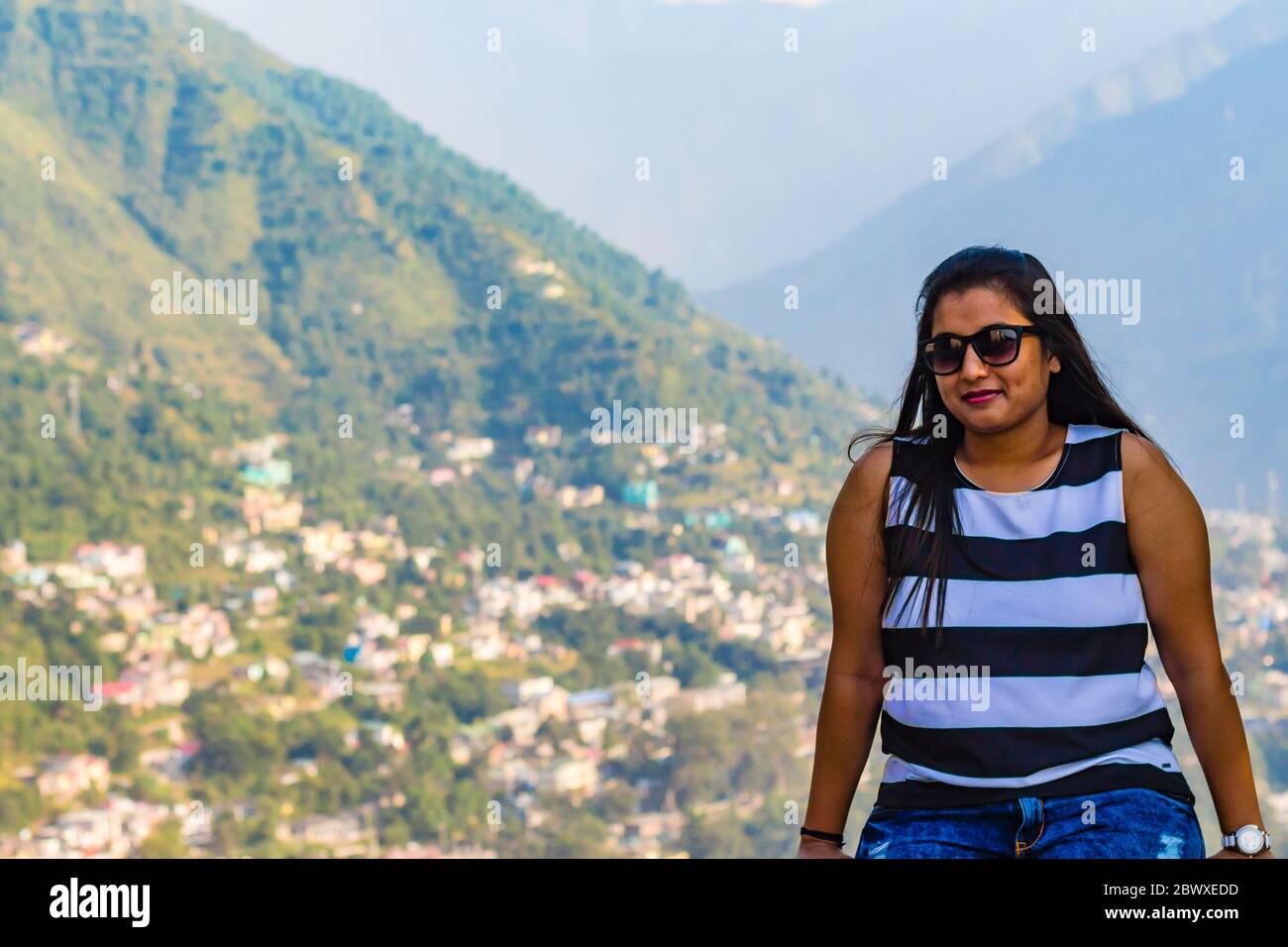 A tourist girl posing for a camera shoot in the green mountains of ...