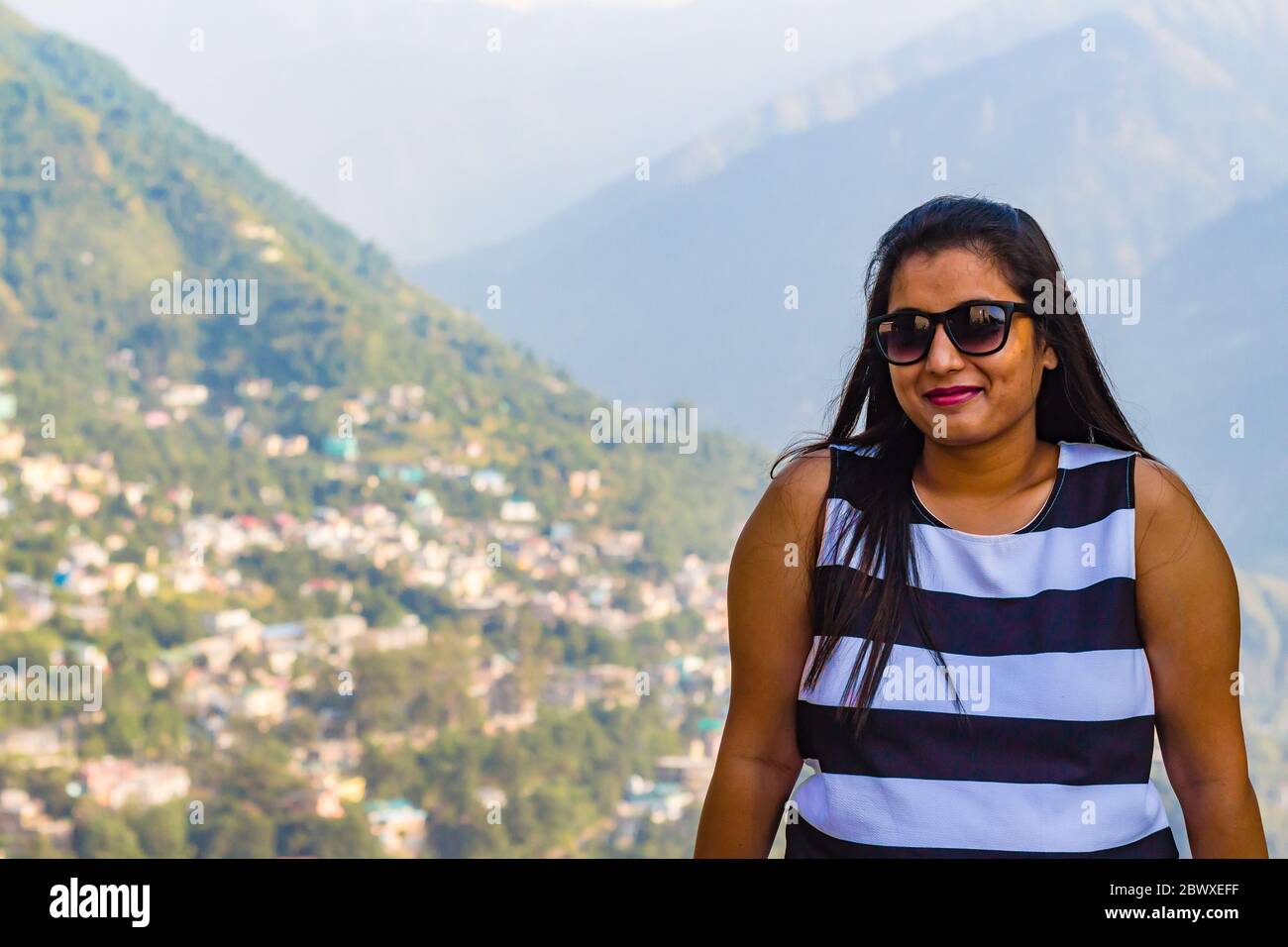 A tourist girl posing for a camera shoot in the green mountains of ...
