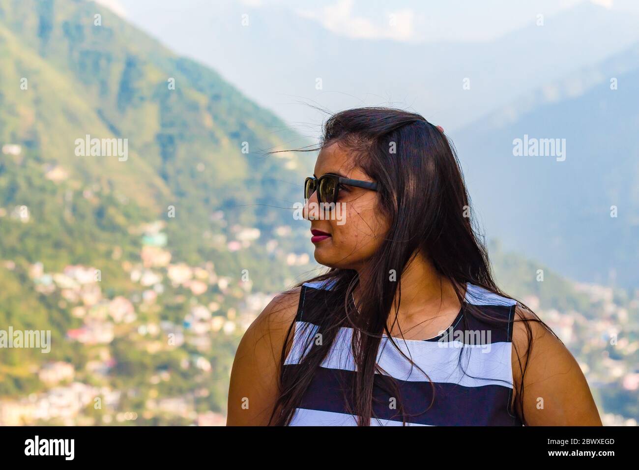 A tourist girl posing for a camera shoot in the green mountains of ...