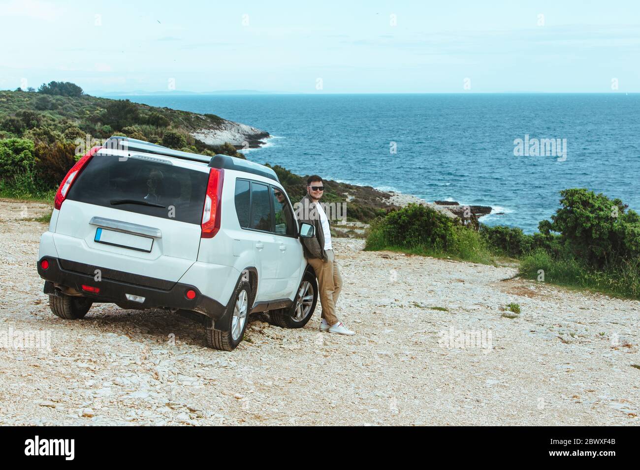 man lean on suv car enjoying view of the sea. summer road trip vacation ...