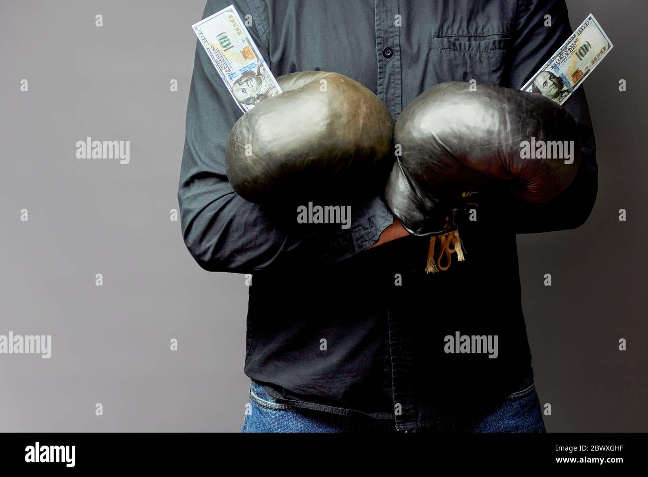 man in leather boxing gloves holds money dollars. business concept ...