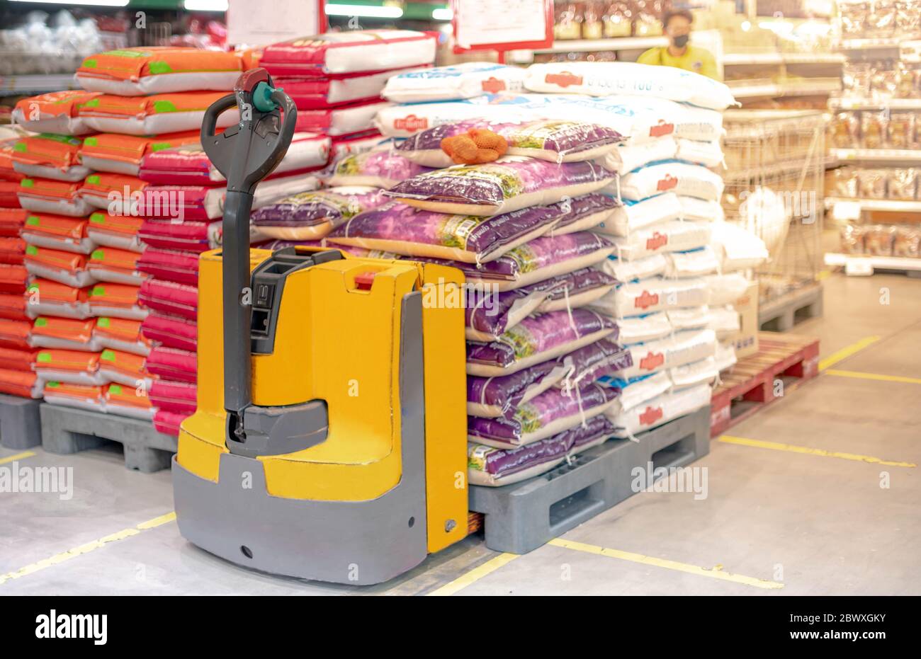 Hand pallet truck with the rice bag and plastic pallets with goods in ...