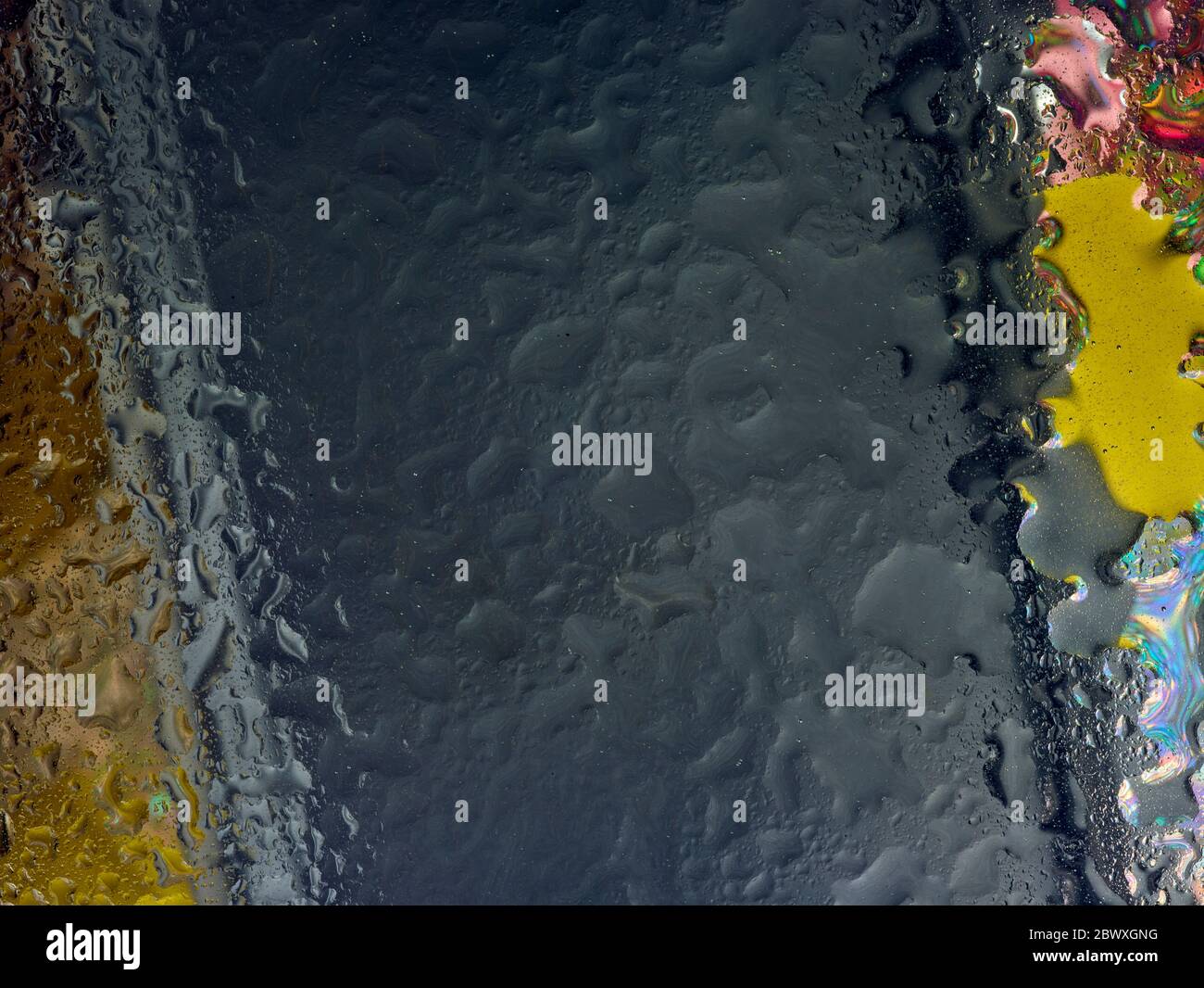 Water drop (drops and droplets) on hard surface with colourful ...