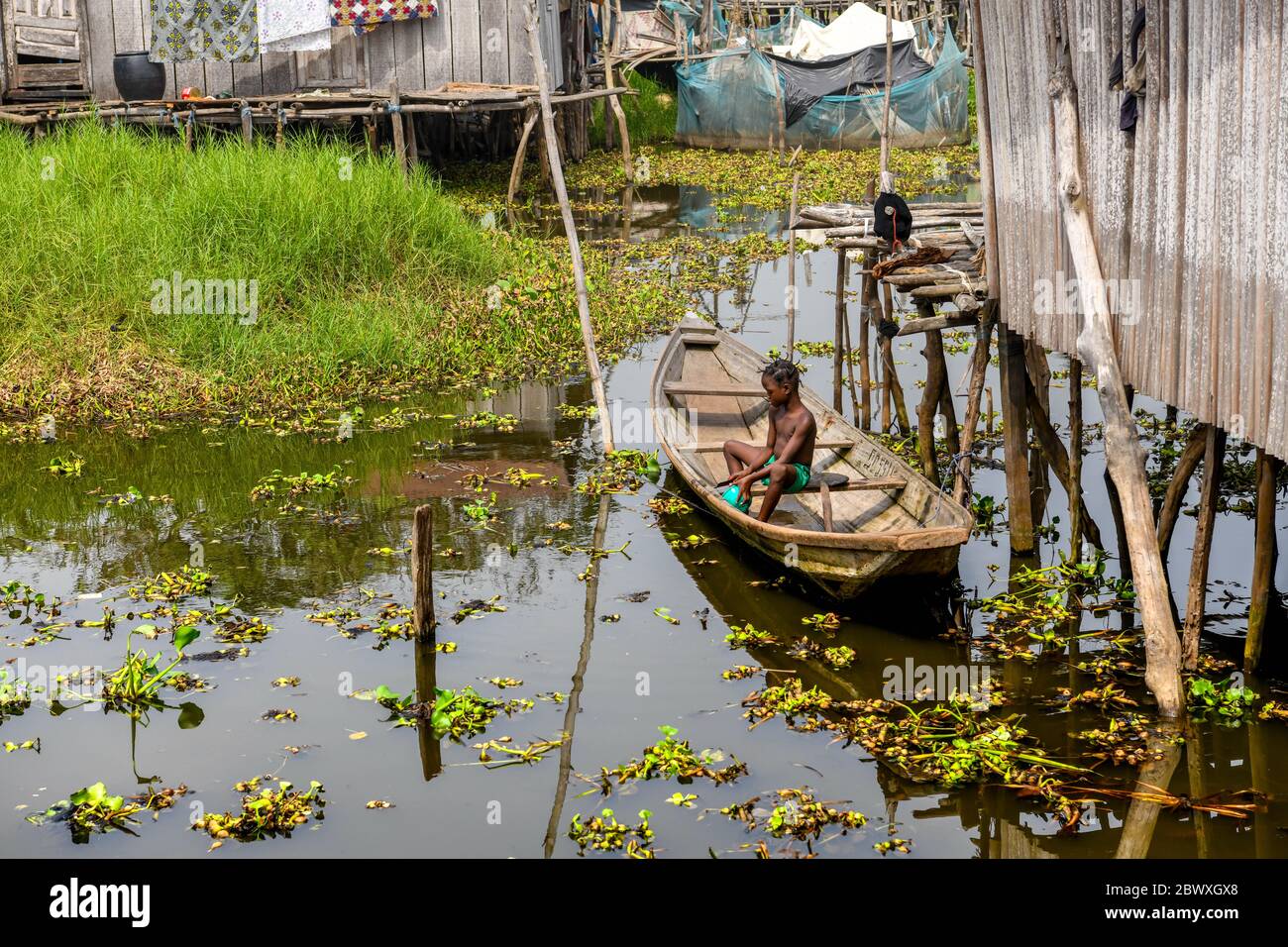 Africa, West Africa, Benin, Lake Nokoue, Ganvié. A child washes up ...