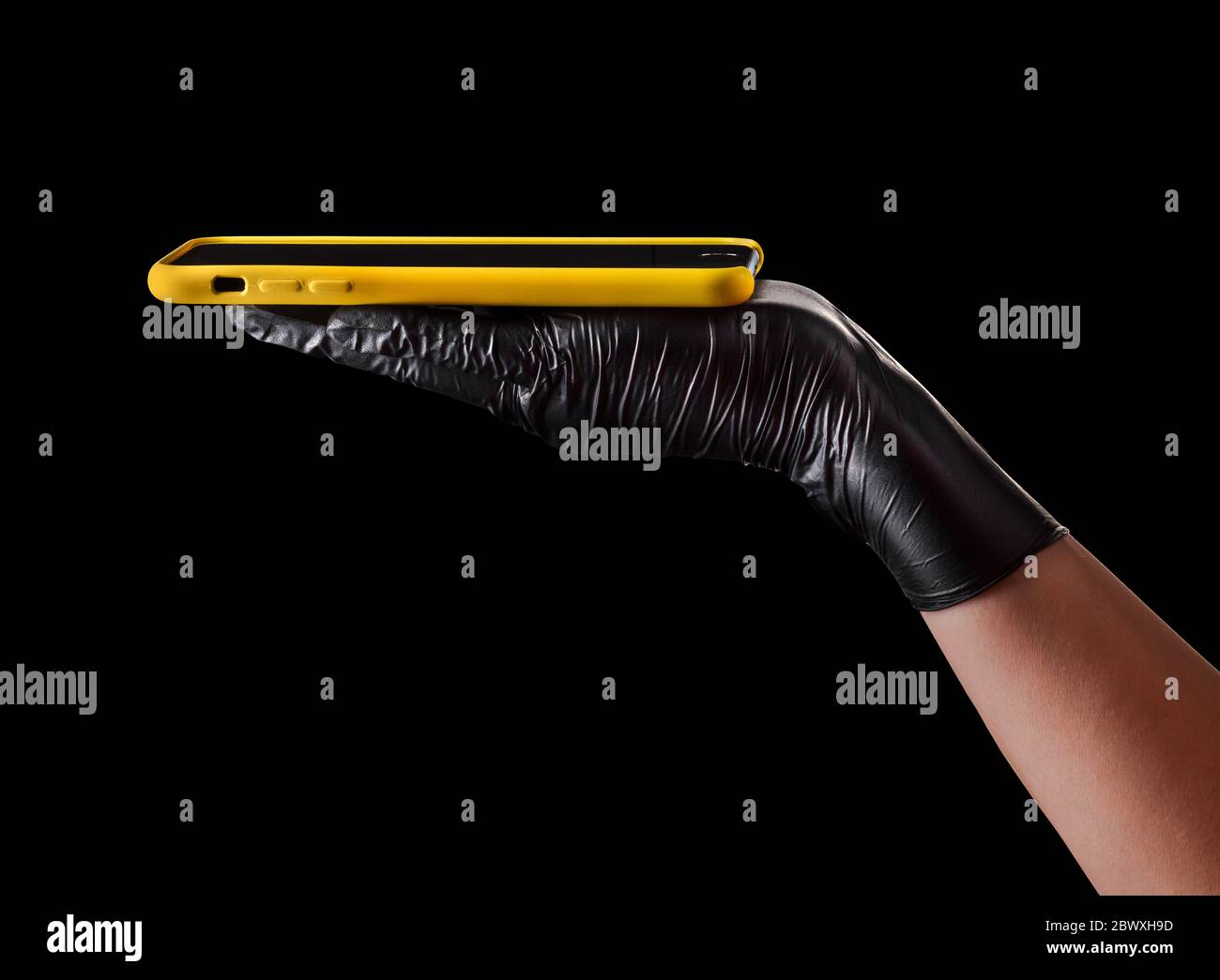 Hand in black glove holding mobile phone with blank screen isolated on ...