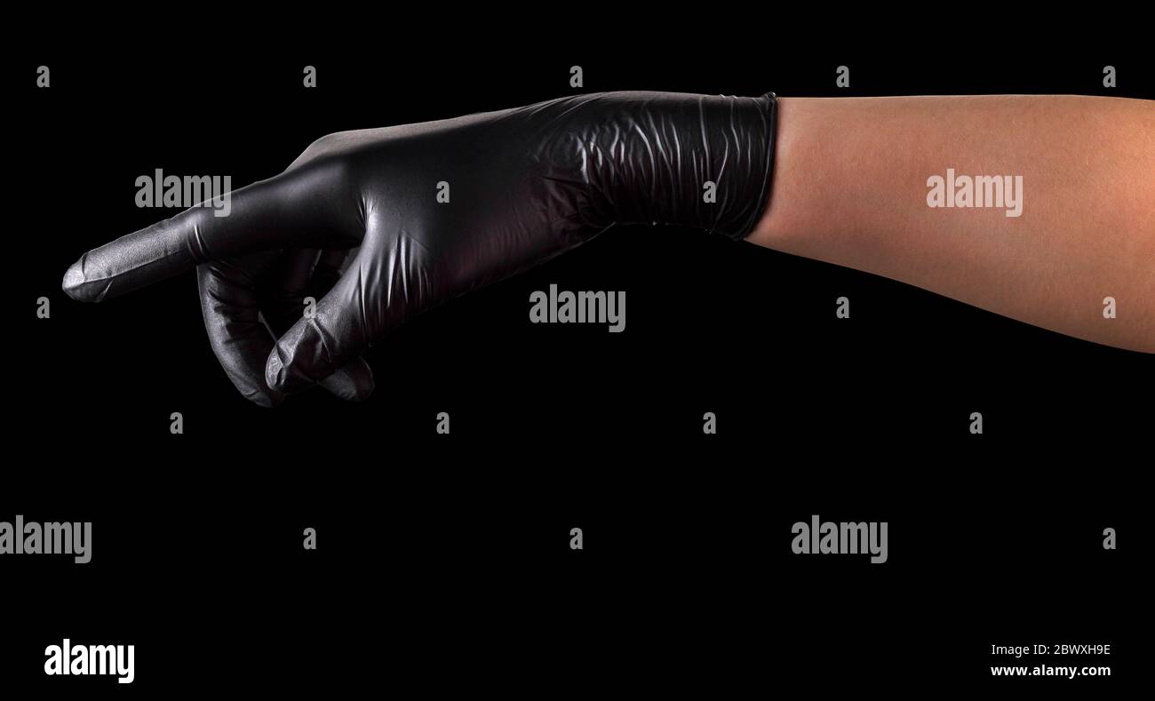 Hand in black gloves with index finger pointing or touching something ...