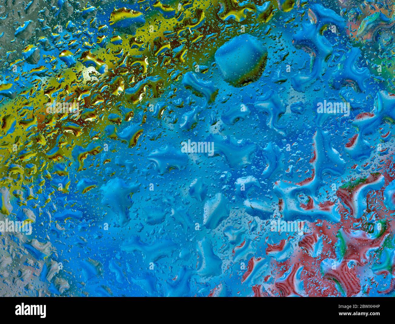 Water drop (drops and droplets) on hard surface with colourful ...