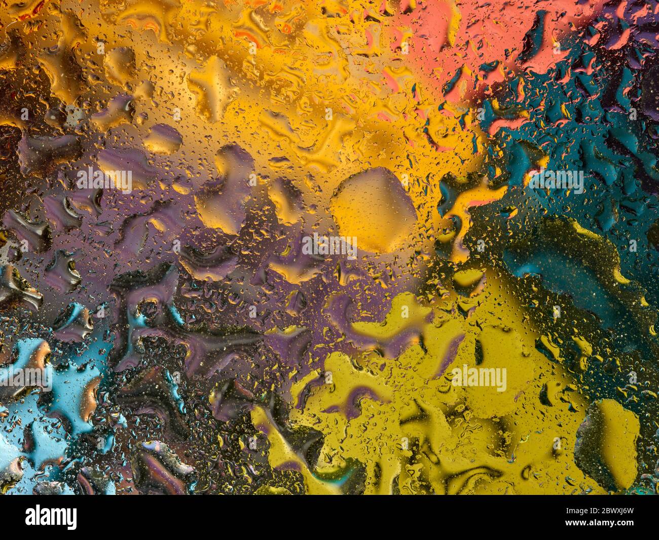 Water drop (drops and droplets) on hard surface with colourful ...