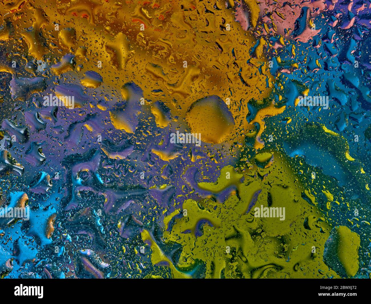 Water drop (drops and droplets) on hard surface with colourful ...
