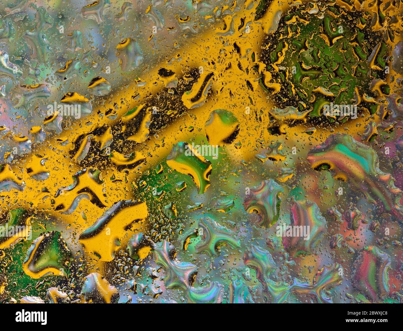 Water drop (drops and droplets) on hard surface with colourful ...