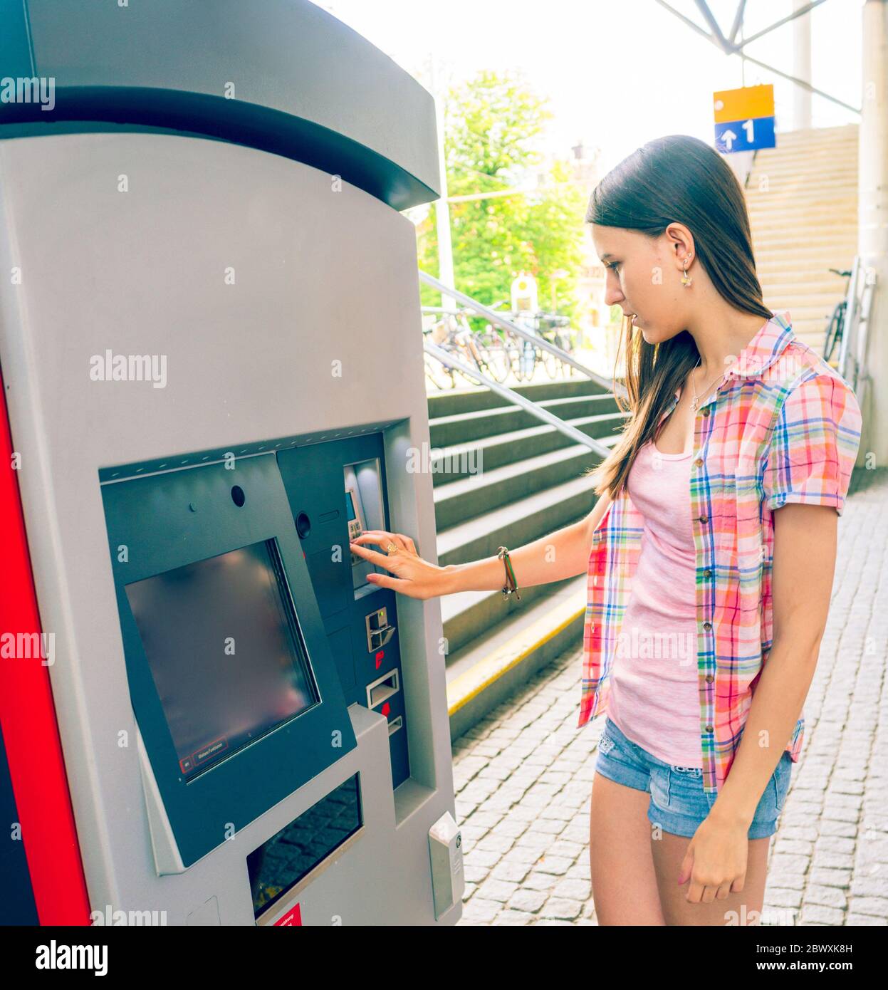 Young woman uses a vending machine for transport tickets Stock Photo ...