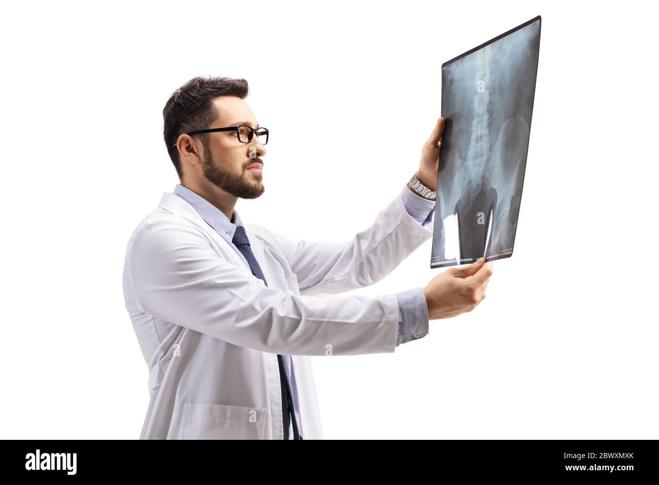 Young male doctor specialist looking at an x ray scan isolated on white ...