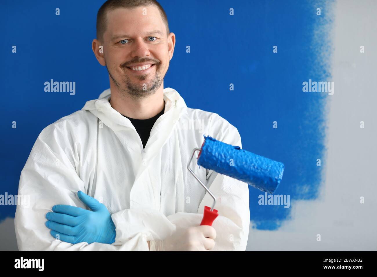 Male painter in uniform with roller in his hand Stock Photo - Alamy