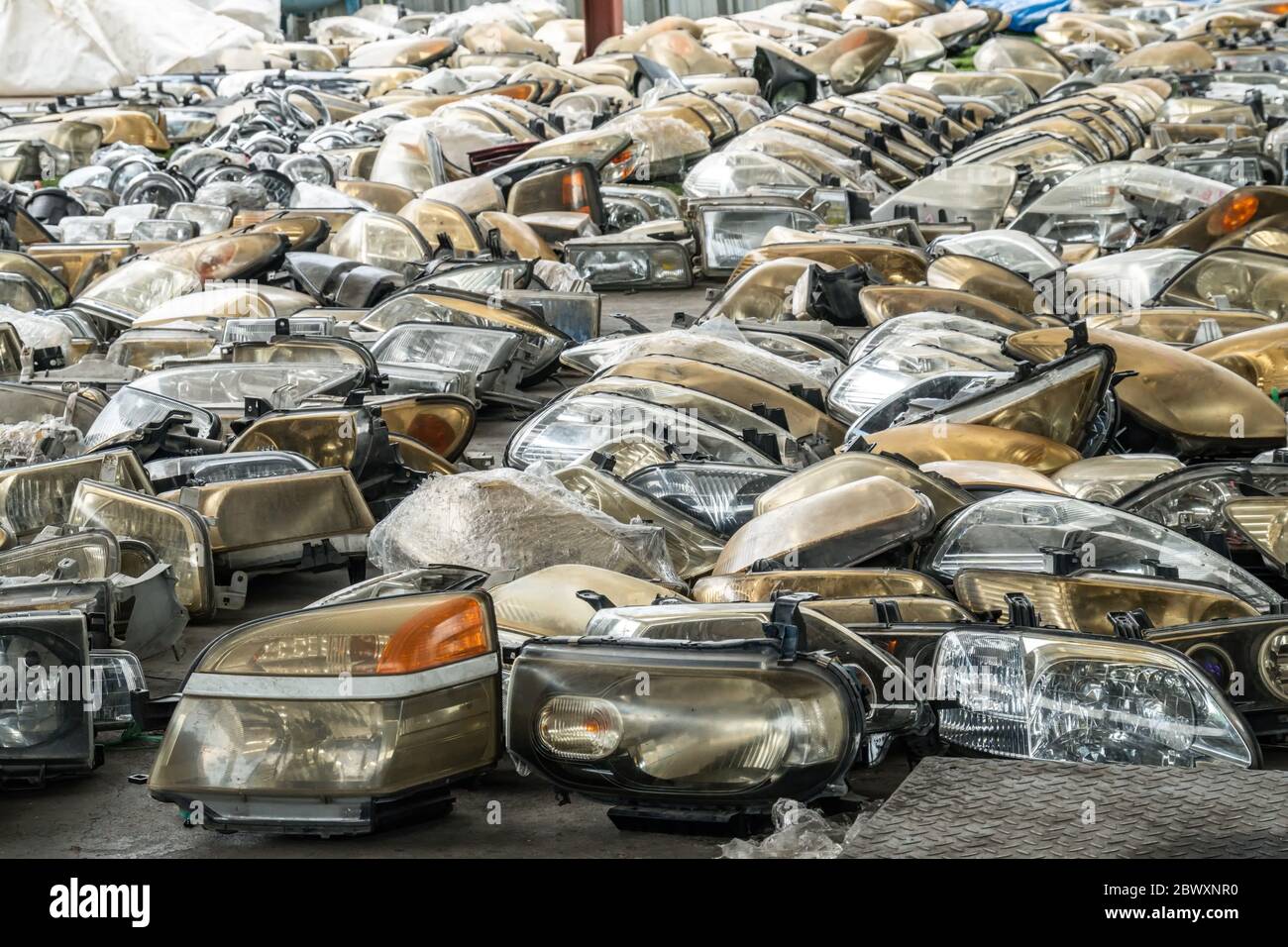 Used headlamp components for sale at scrapyard area Stock Photo - Alamy
