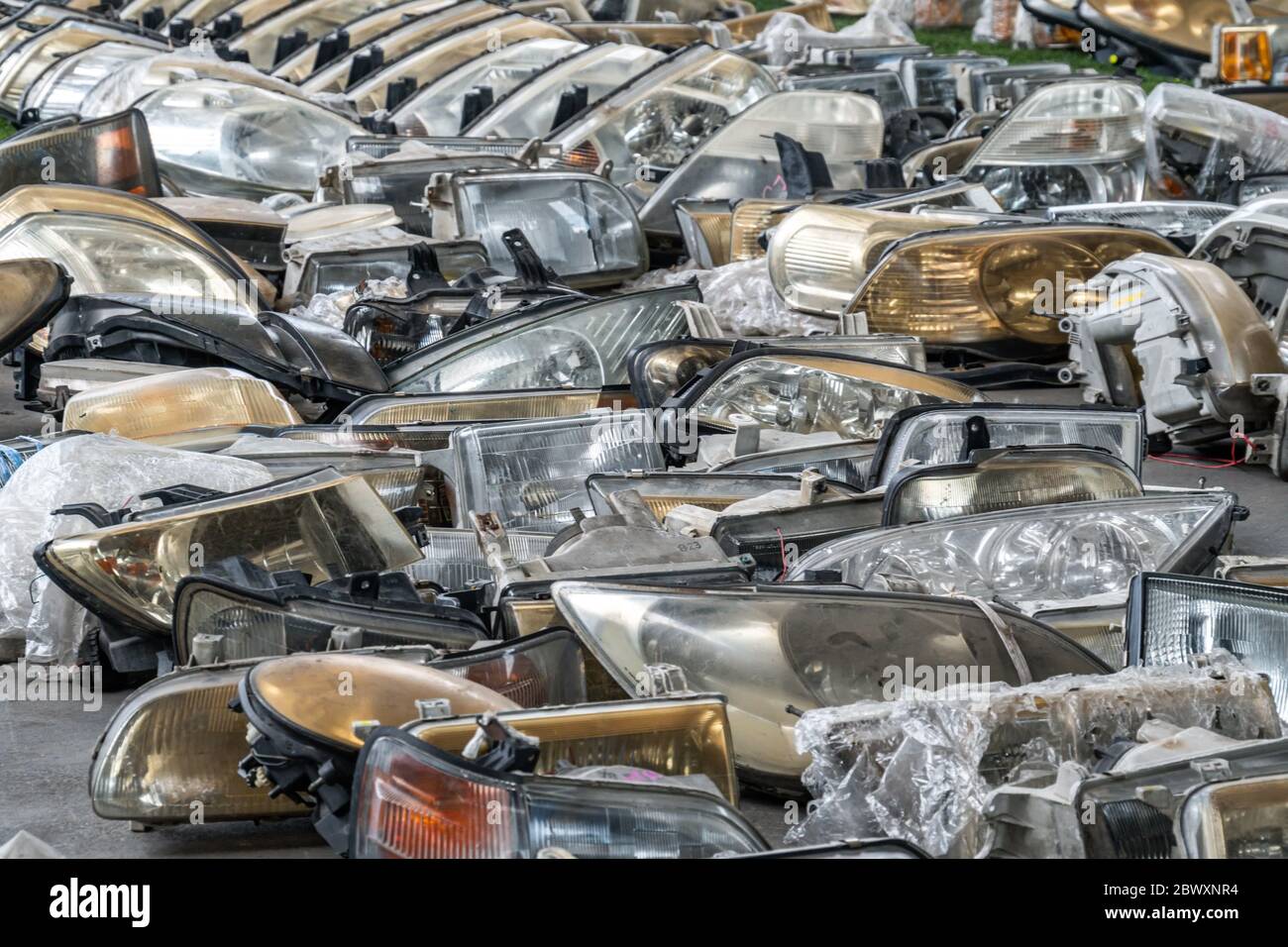 Used headlamp components for sale at scrapyard area Stock Photo - Alamy