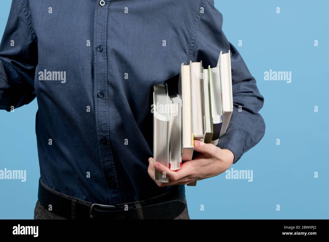 Young guy holds a stack of books with one hand, Close up Stock Photo ...